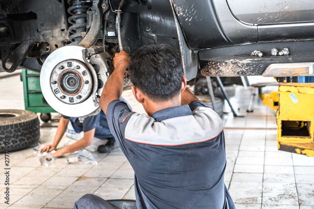 Fotka „Car mechanic worker woking for reparing and replacing car's disk ...