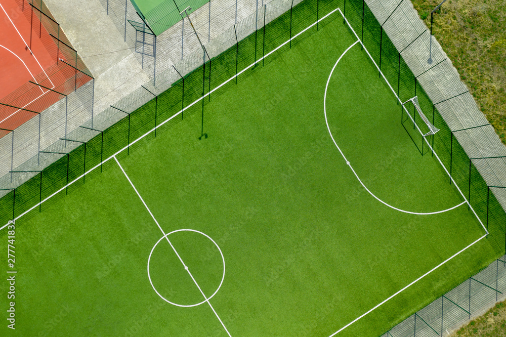 Aerial view from below on a large green football field with white lined ...