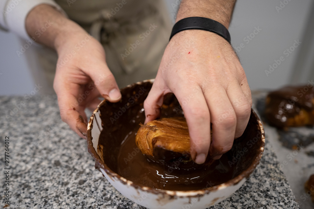 From above crop man in apron dipping crunchy croissants in bowl with ...