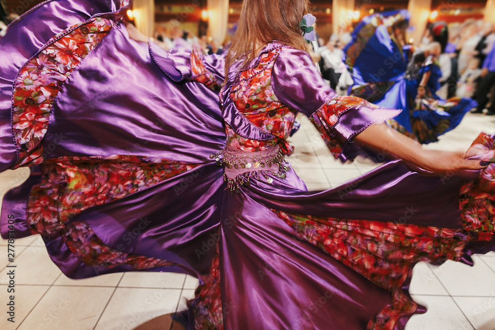 Beautiful gypsy girls dancing in traditional purple floral dress at ...