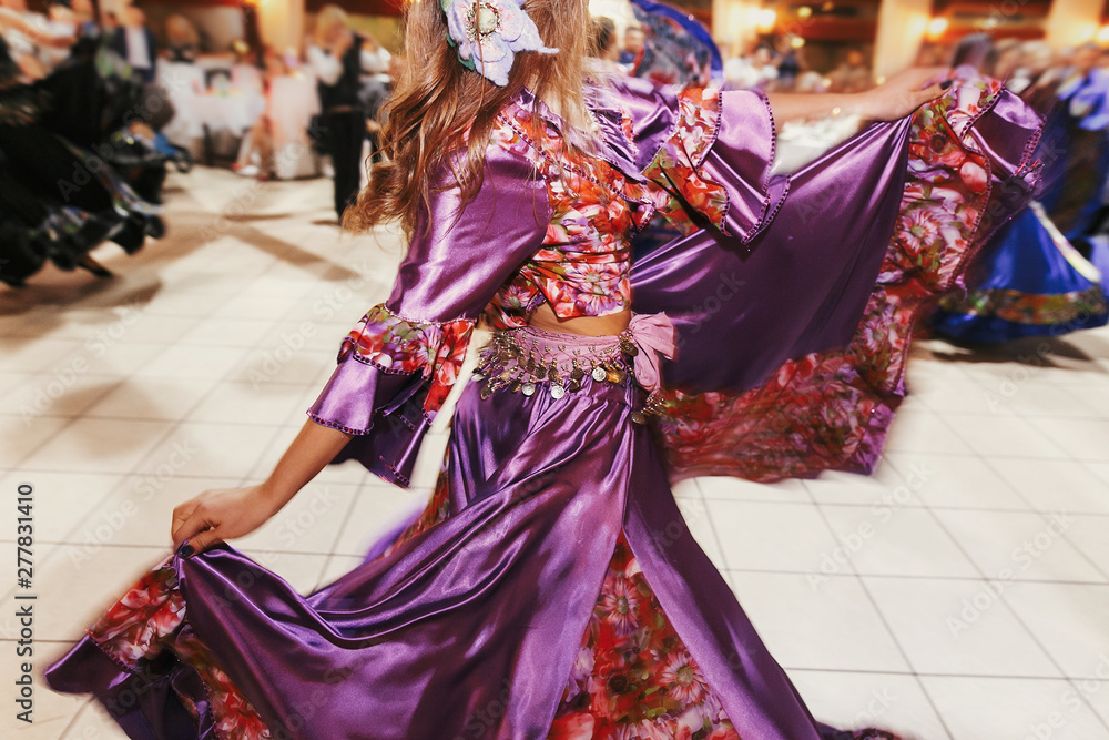 Beautiful gypsy girls dancing in traditional purple floral dress at ...