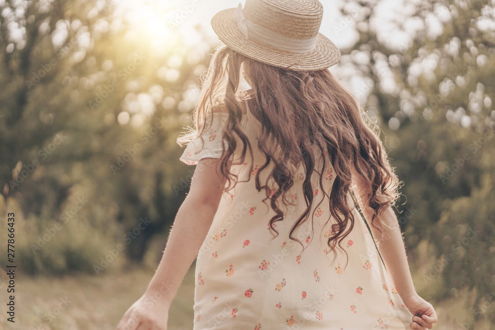 Back view portrait of young happiness pretty girl in garden on sunset ...