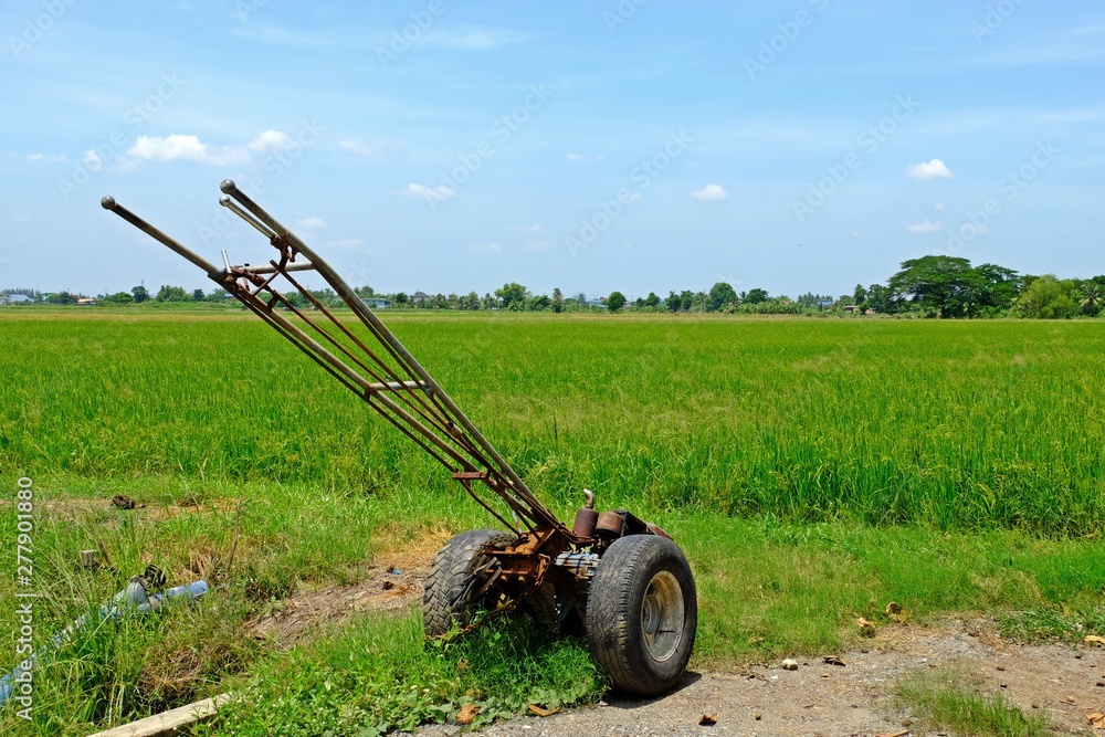 Foto de Idle walking tractor on rice field ready to be used at the ...