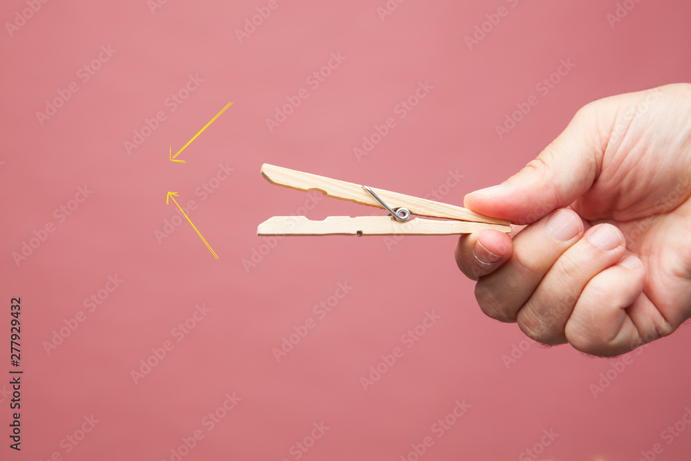 Mano que sujeta una pinza de extender la ropa, la pinza en formato ...