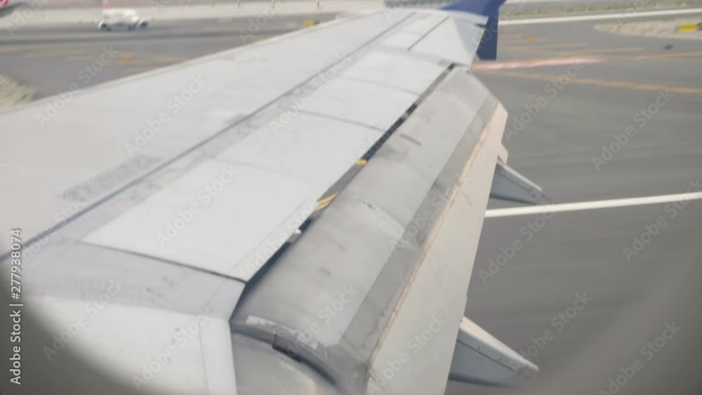 Plane landing on the runway, detail of wing, spoilers and ailerons ...