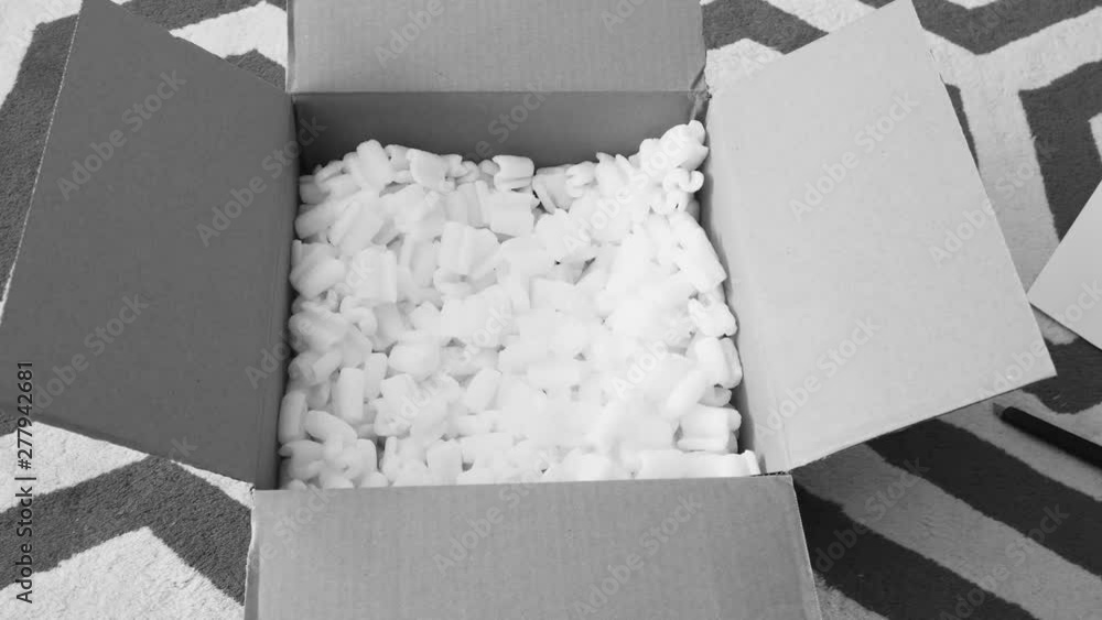 Man hand unboxing unpacking the cardboard box with foam protection ...