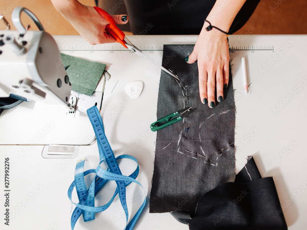 Tailor workshop. Top view cropped shot of seamstress cutting fabric ...