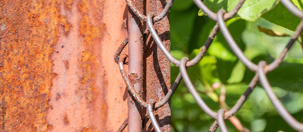 Rows of wire mesh and rusty metal pillar of fence. Wire mesh grid ...