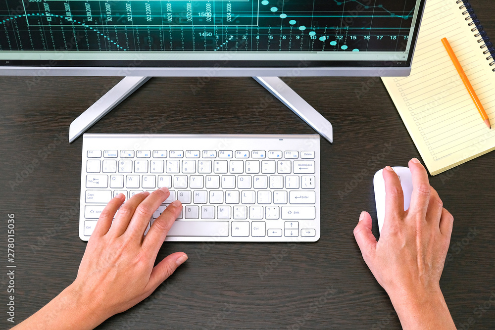 Stock chart on the monitor. Office Desk with computer and keyboard in ...