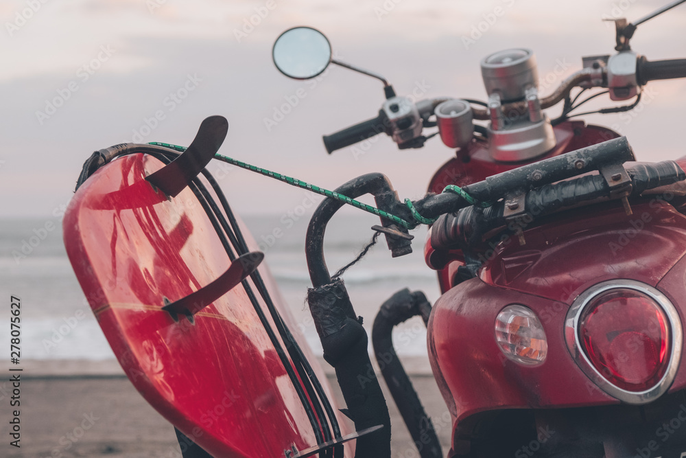 Moto con tabla de surf aparcada frente al mar al atardecer Stock Photo ...