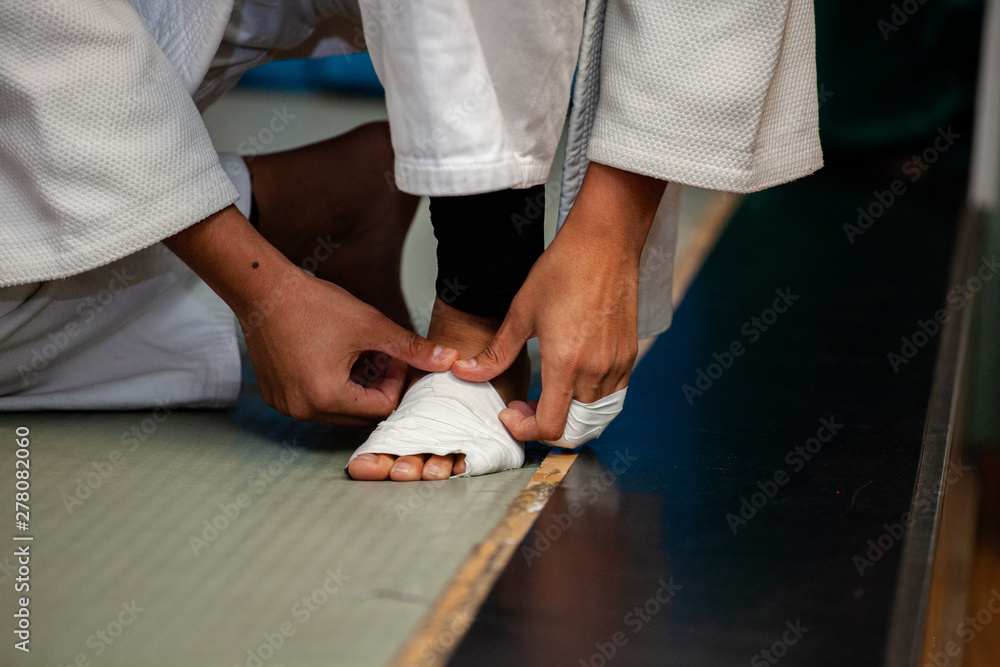 The athlete bandages his injured leg before judo training. Judo ...
