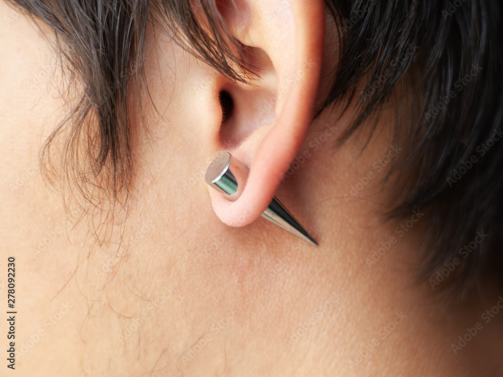 piercing in the ear, tunnels in the ears of a young man lifestyle Stock ...