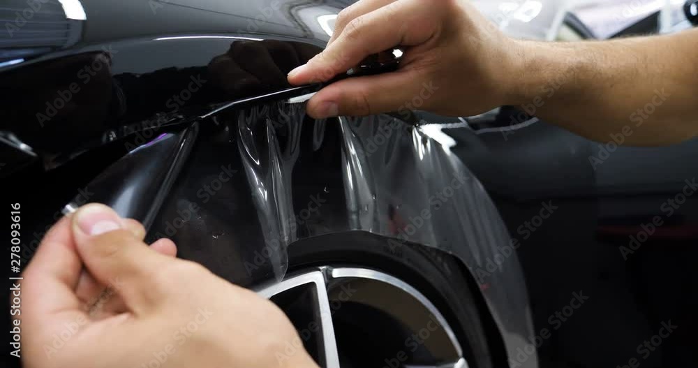 Close up to PPF installation process on a front headlight and hood. PPF ...