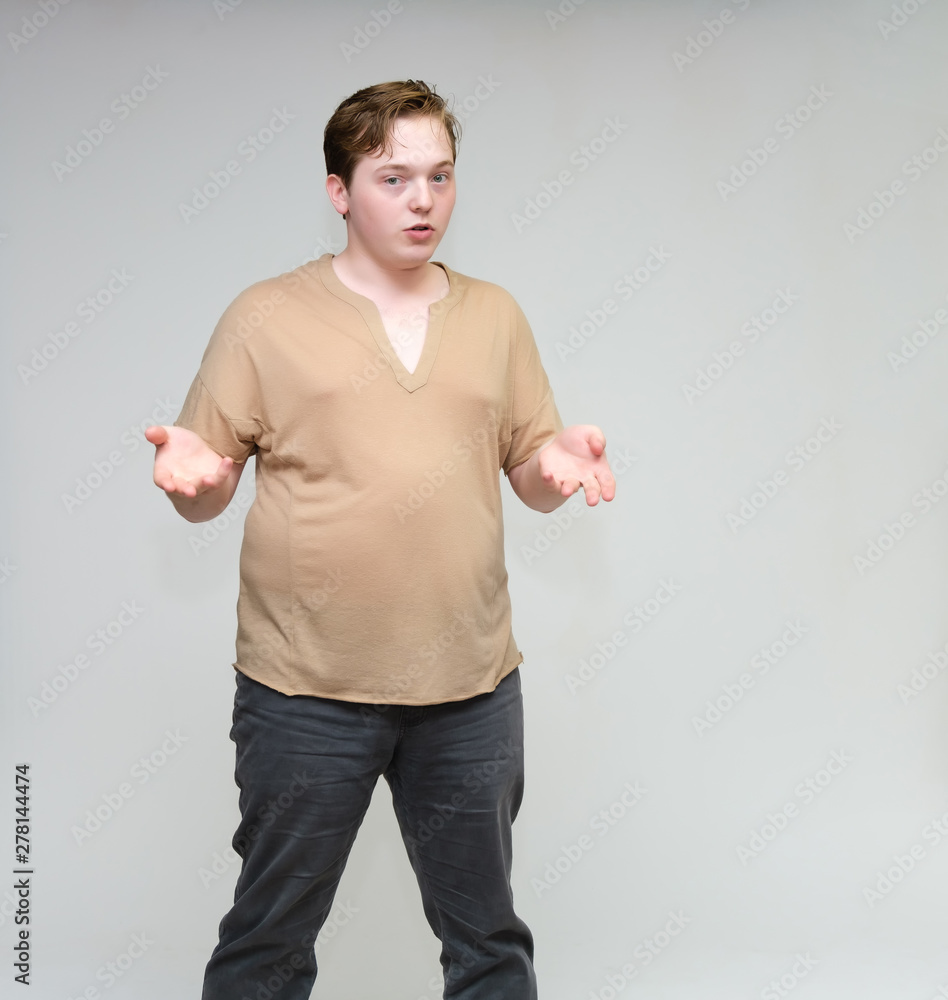 Portrait of a knee on a white background cute young man in a brown T ...