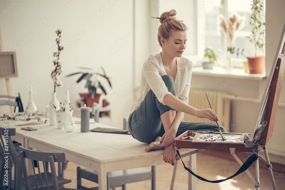 talented artist sitting on the table and drawing her picture at home ...