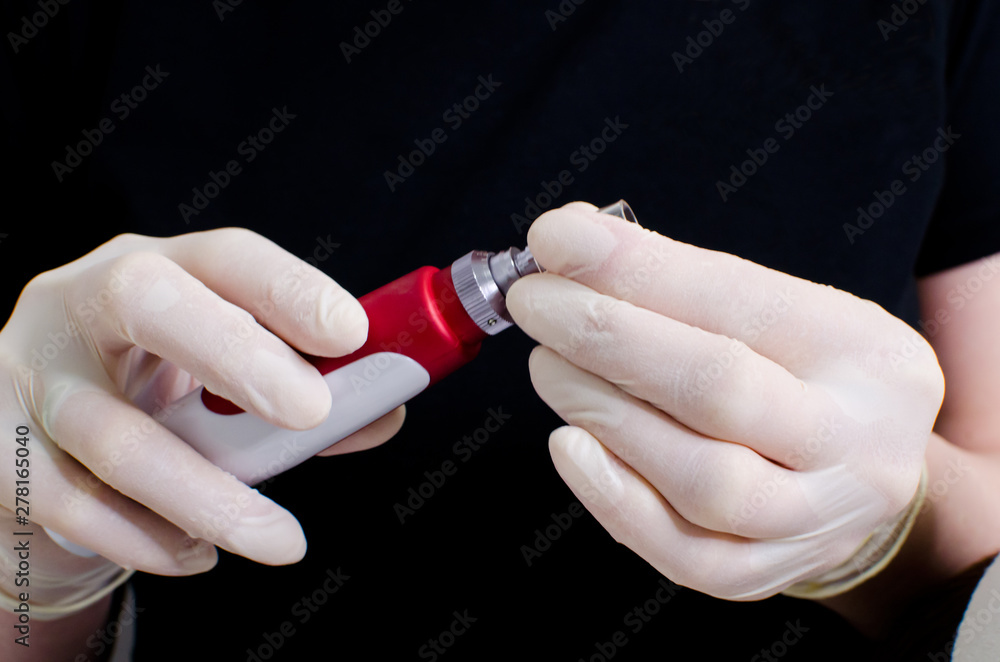 beautician in white gloves holding dermis stamp electric pen, dermapen ...