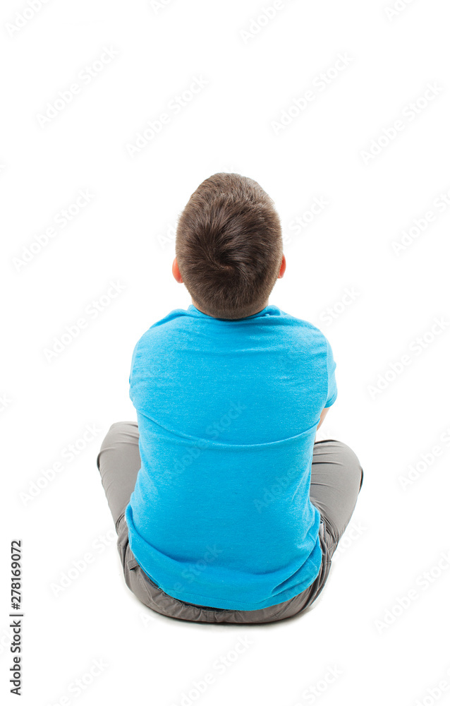 Back view of little boy sitting on floor looking at wall. Rear view ...
