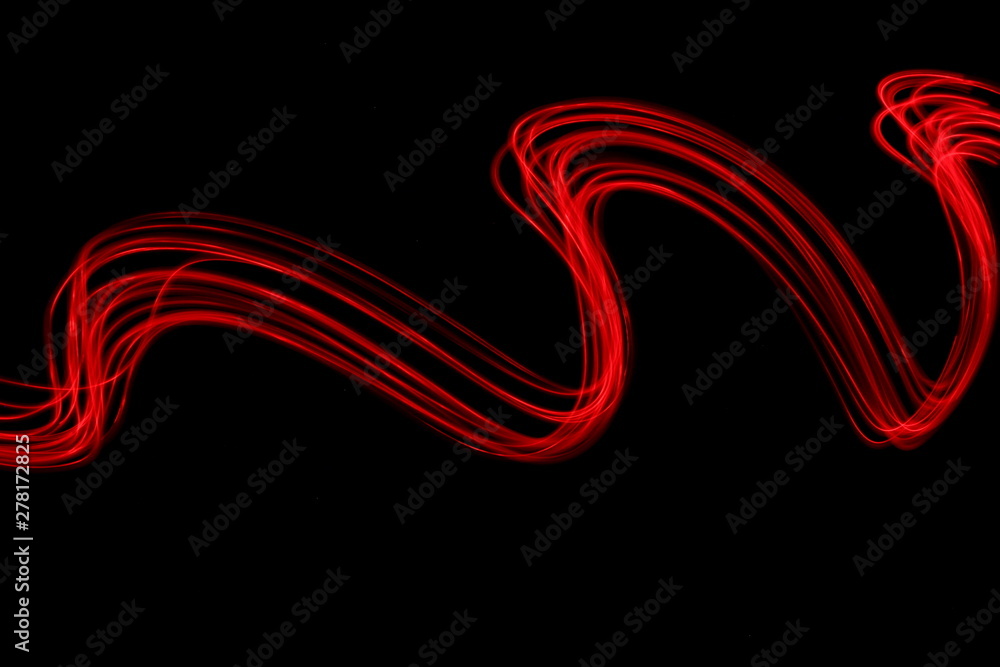Long exposure photograph of neon red colour in an abstract swirl ...