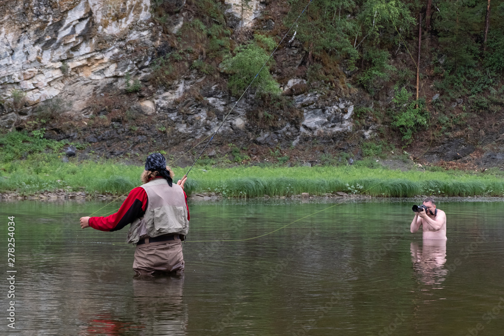 Fly fishing and undressed photographer in the river. Reportage ...