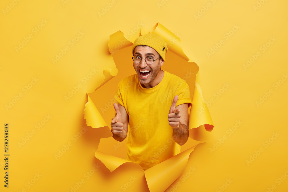 Joyful young optimistic man points fingers at you, has confident ...