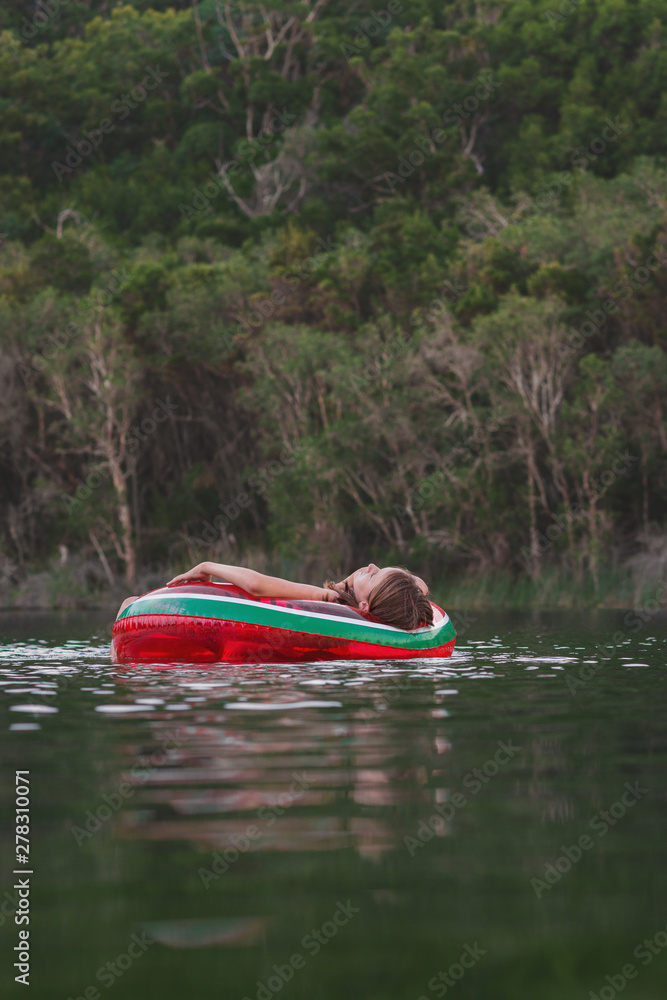 young teen floating on a blow up tyre tube on a lake Stock-Foto | Adobe ...