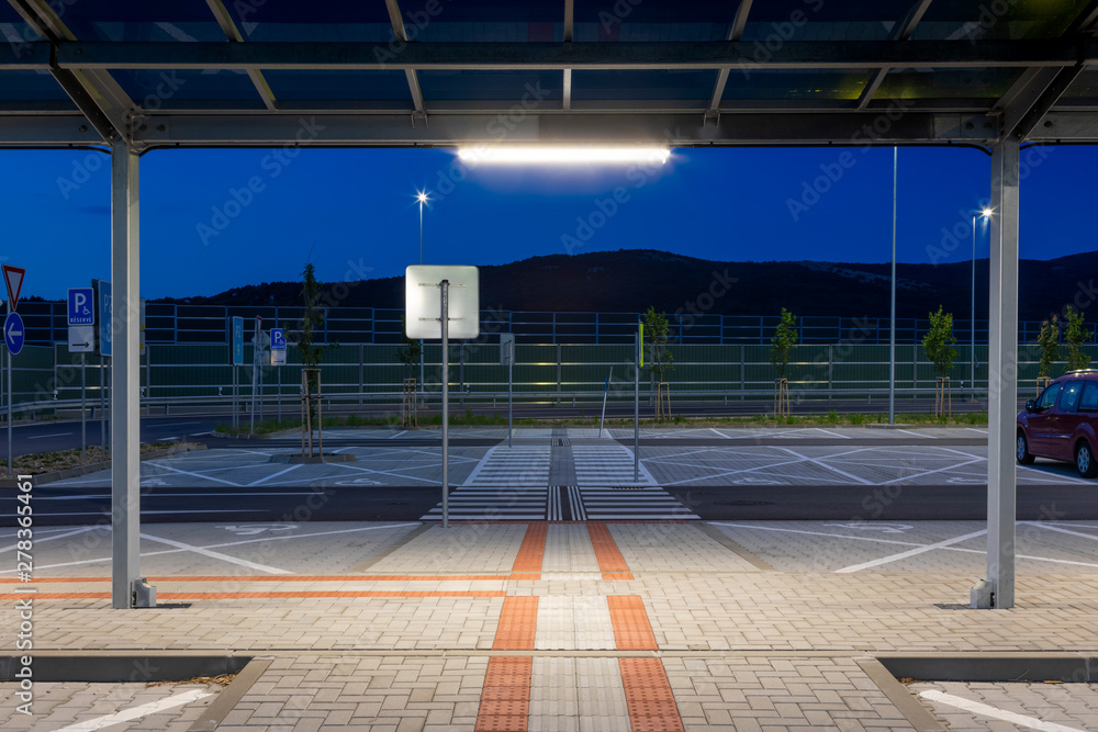 covered corridor for pedestrian in a modern parking lot at night with ...