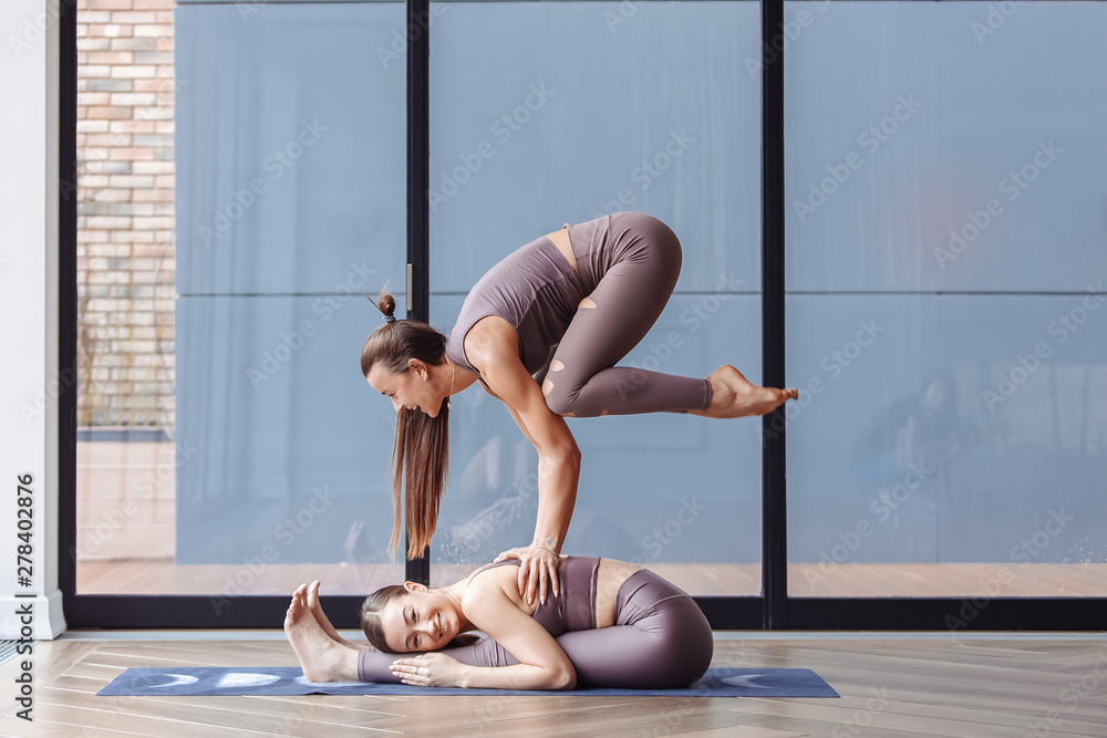 Two beautiful girls acrobats prepare for competitions practicing in a ...