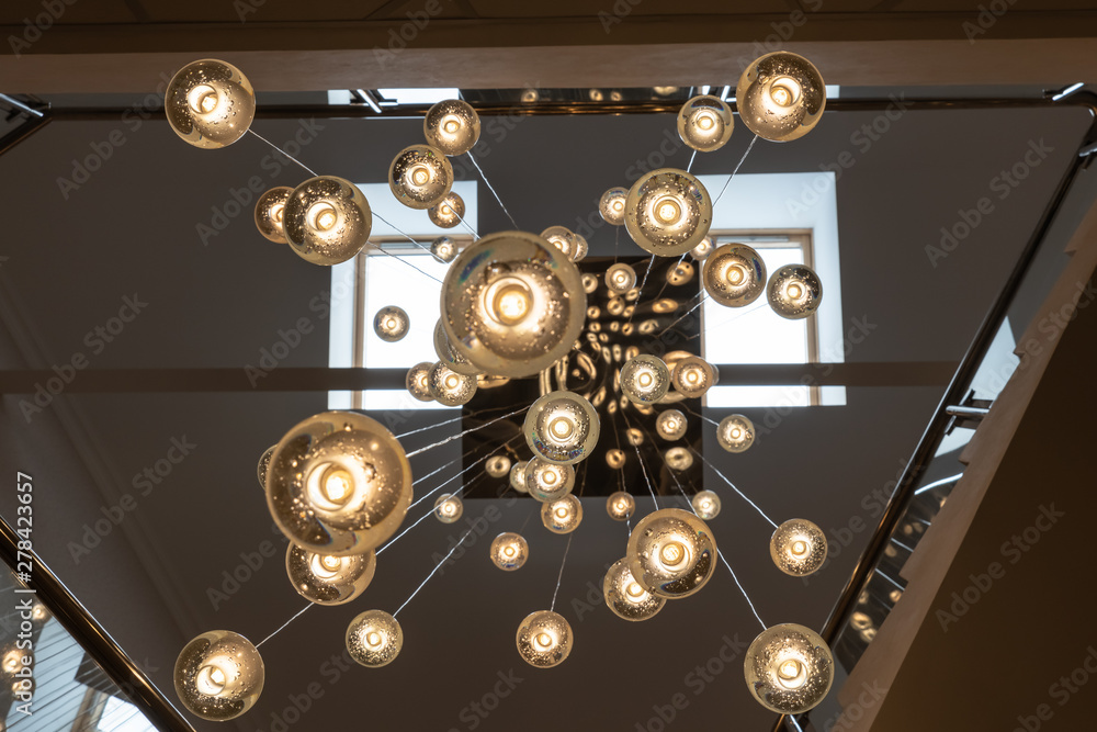 Many light bulbs that go down with their cables from the ceiling ...