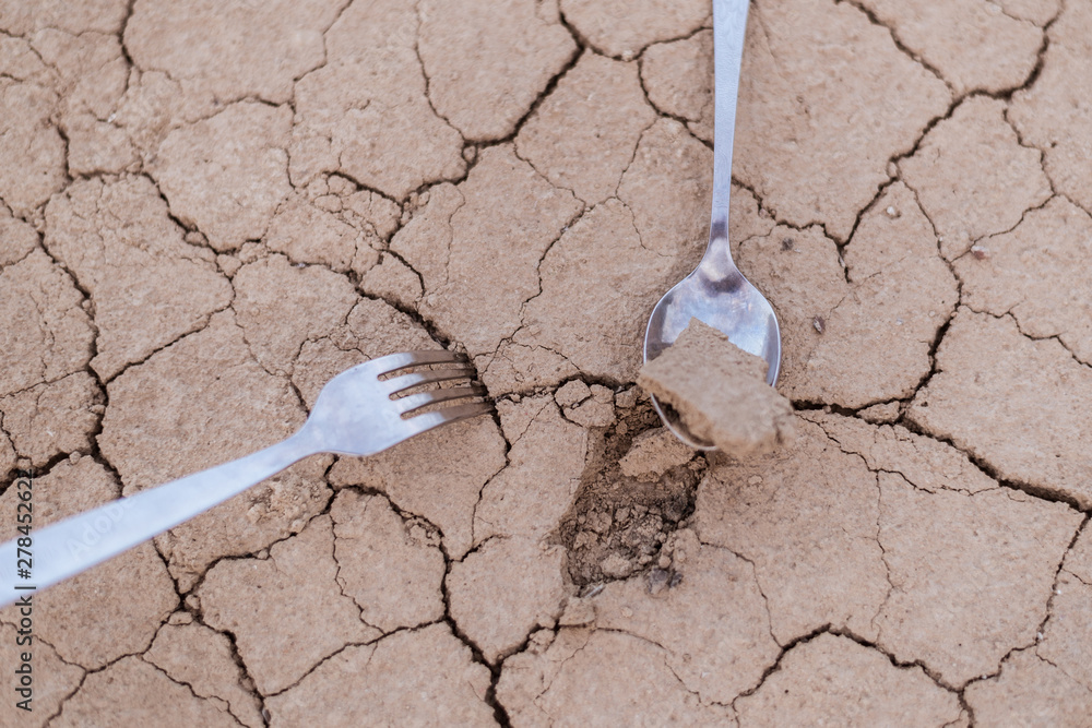 Foto de Fork stuck in the dry cracked ground. The concept of drought ...