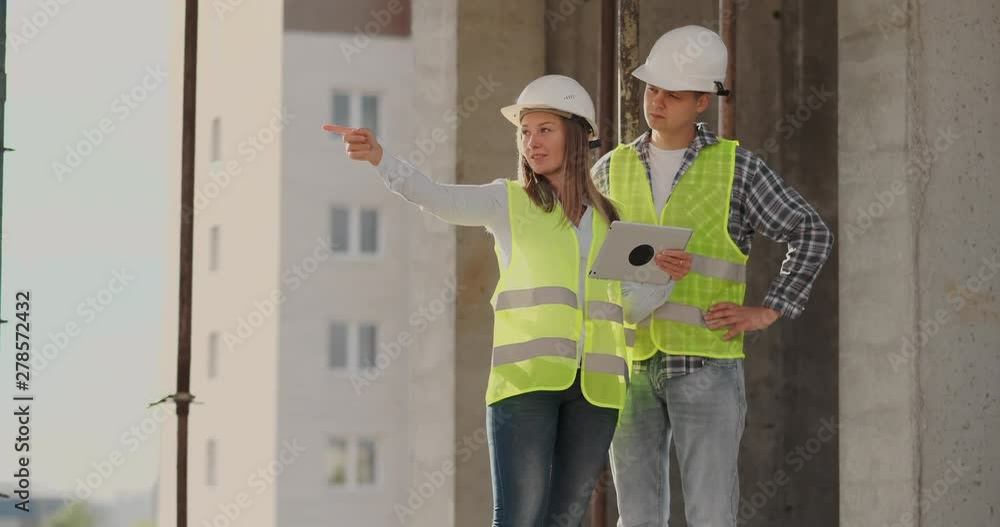Construction worker man and architect woman in a helmet, discuss the ...
