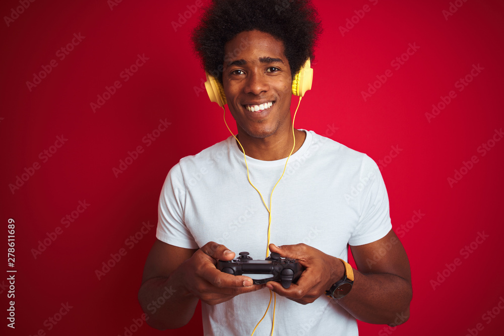 Afro gamer man playing video game using joystick headphones over ...