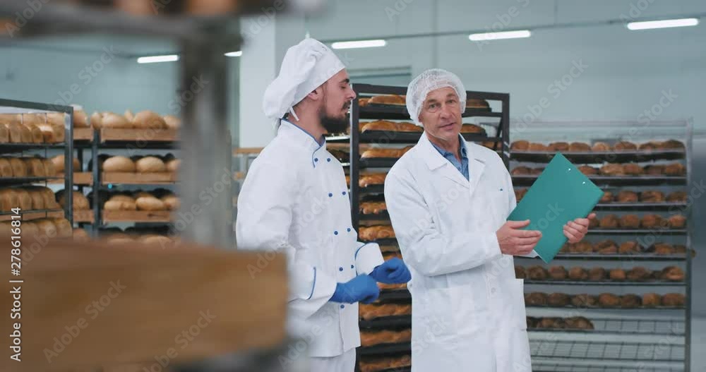 In a bakery factory young baker and old man engineer have a ...