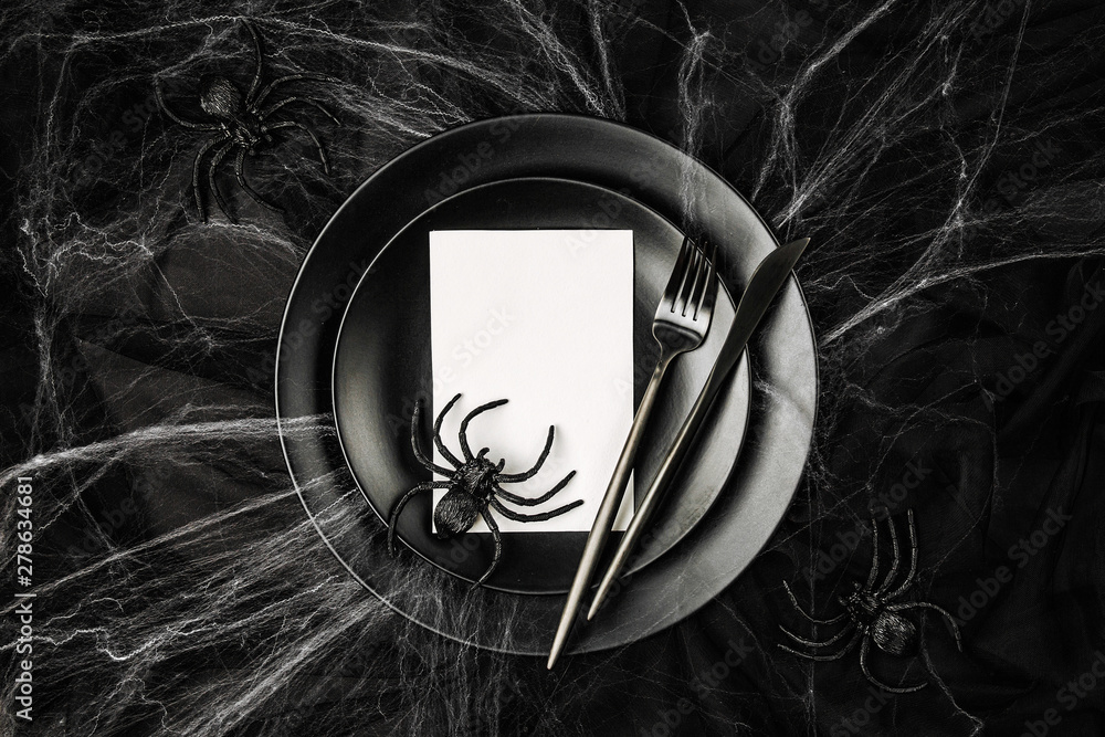 Halloween Table setting on dark background. Dish with blank card on a ...