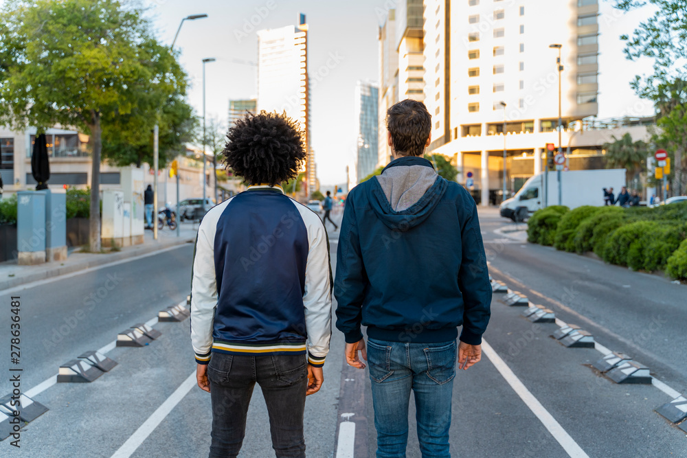 Rear view of two men standing on the street in the city, Barcelona ...