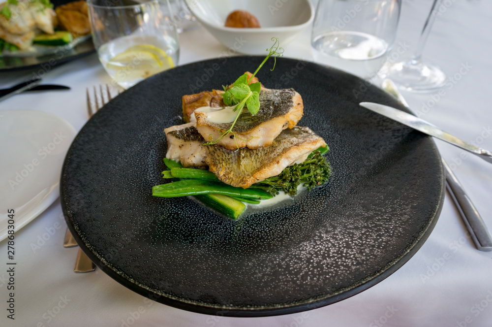 Dark plate with grilled fish fillets and green vegetables Stock Photo ...