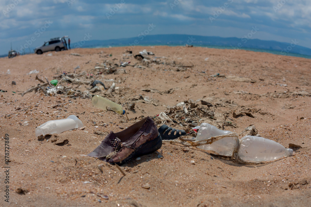 Polluted sand beach full of plastic bottles and other garbage the left ...