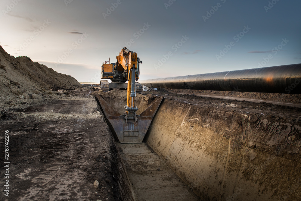 Crane digging a channel for gas pipeline Stock Photo | Adobe Stock