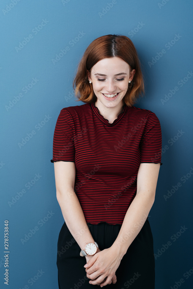 Cute coy young woman looking down with a smile Stock Photo | Adobe Stock