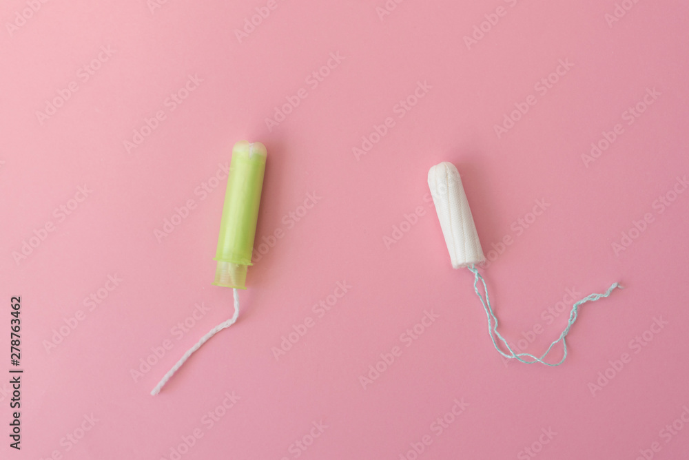 Two cotton tampons with light green applicator and without applicator ...