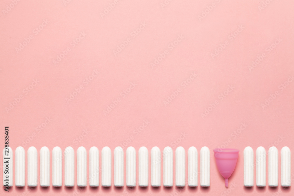 Reusable silicone menstrual cup and heap of tampons comparison on a ...