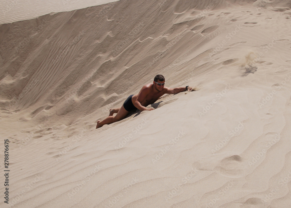 Athletic man in the sand dunes. Man is saved in the hot desert. Stock ...