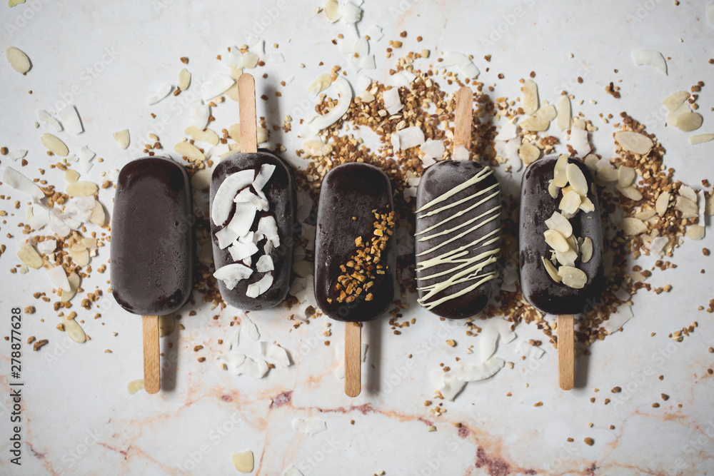 Top view of assorted chocolate ice cream popsicles covered with ...