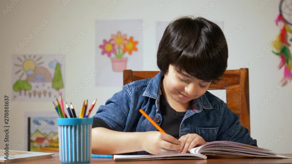 Talented Indian boy picking the color pencil to draw a picture ...