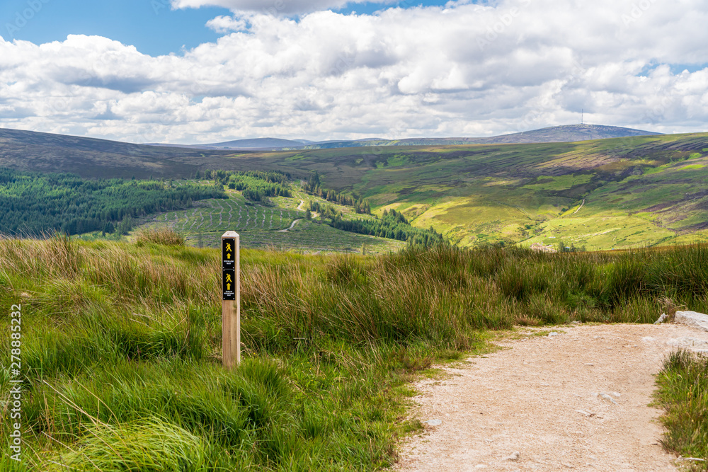 Foto de Irish mountain landscape with a hiking path and a trail marker ...