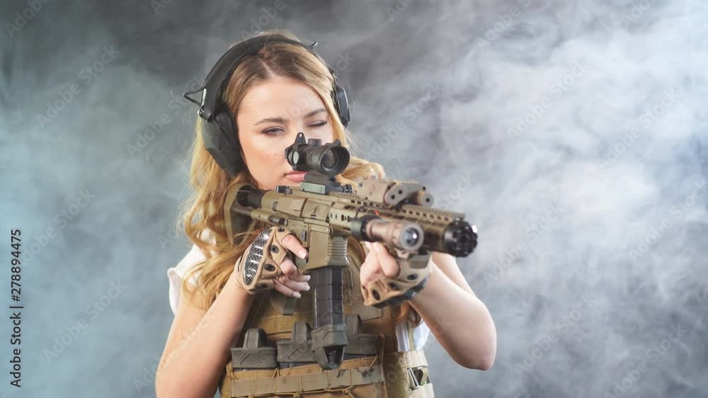 Girl marksman in sniper gear holding sniper rifle in hand aiming at ...