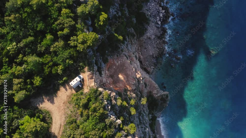 Top down view of a camper van parked on the edge of a rock with a ...