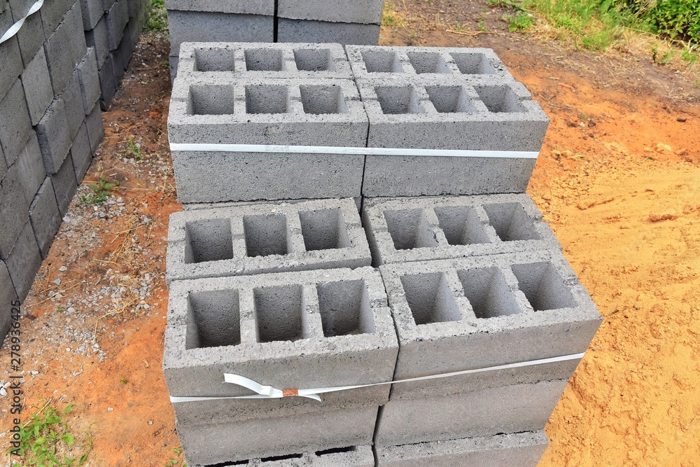 Stack of gray textured cinder blocks for house or fence building ...