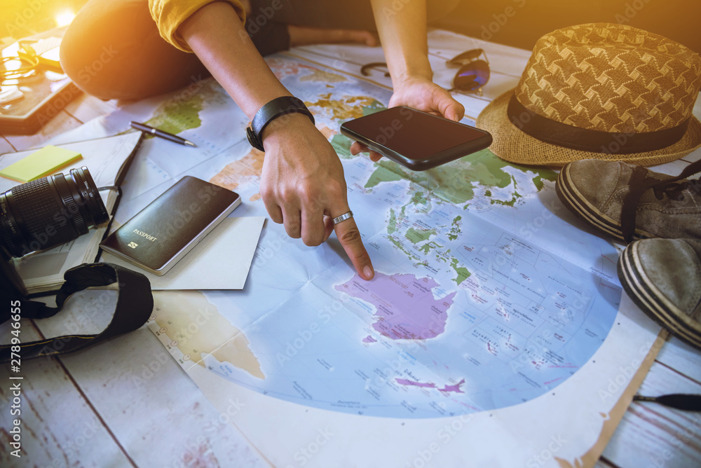 Tourist planning vacation with the help of world map Overhead view of ...