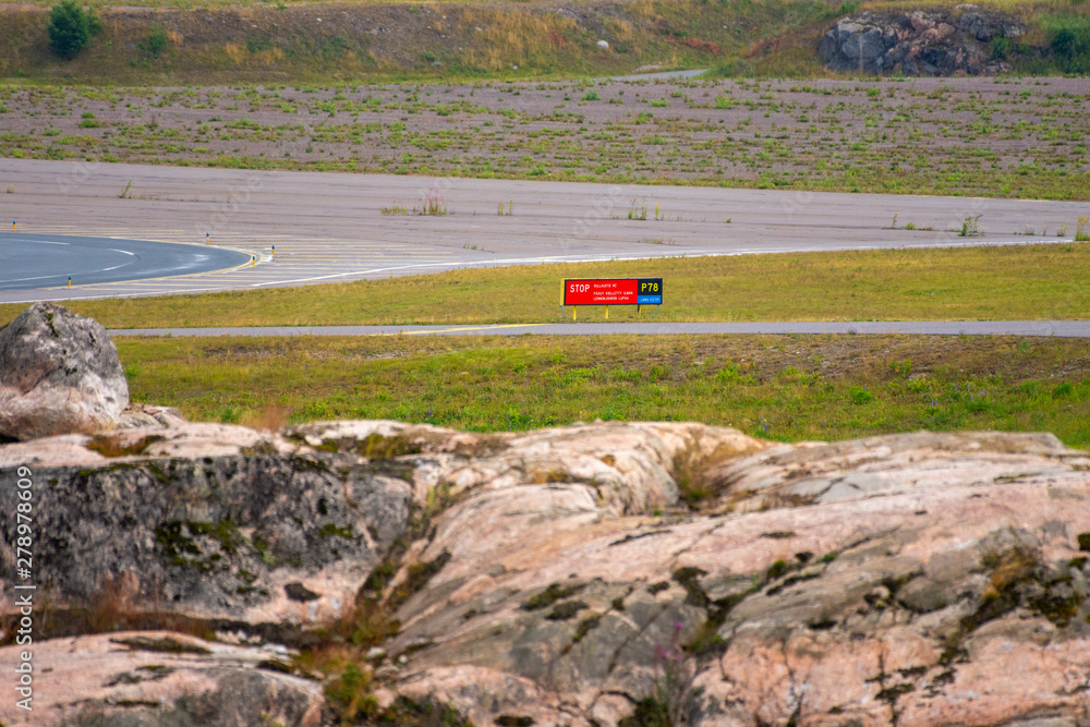 A stop sign with aviation markings on airport tarmac right next to ...