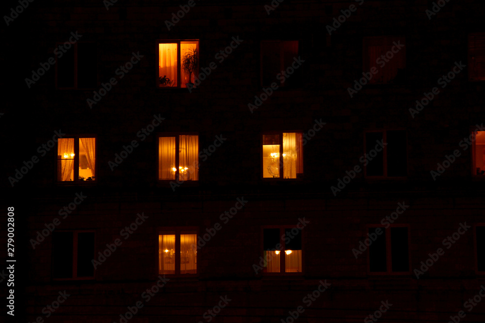 Illuminated in the dark of the night the windows of the houses of an ...